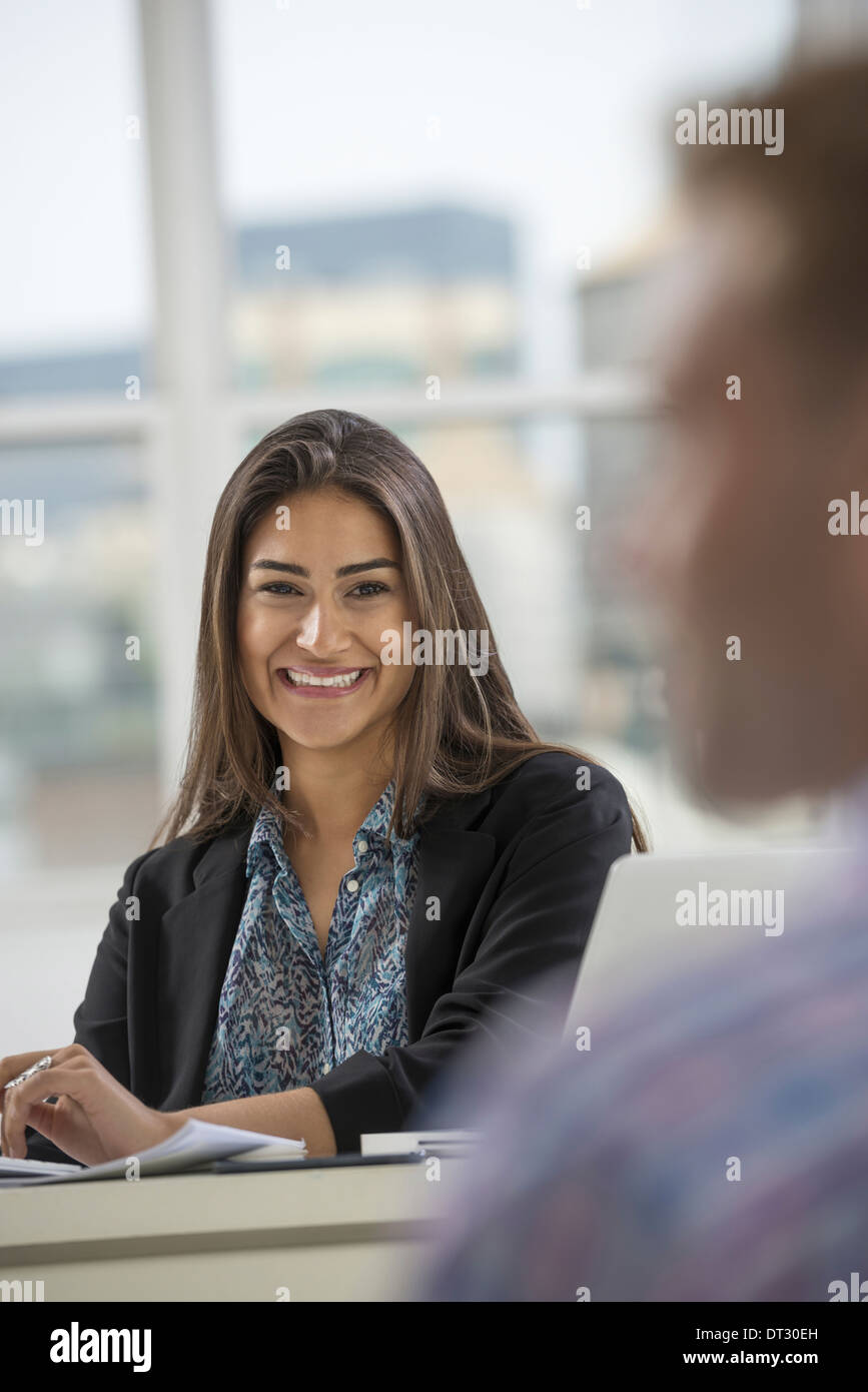 A man and woman seated across a table talking Stock Photo - Alamy
