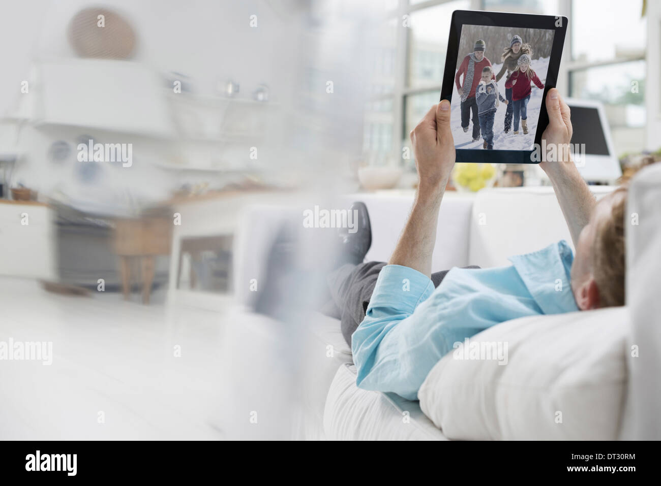 A man lying on a sofa in comfort in a quiet airy office environment ...
