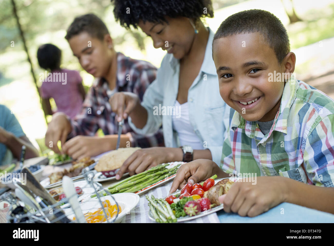 Parents and children helping themselves to fresh fruits and vegetables ...