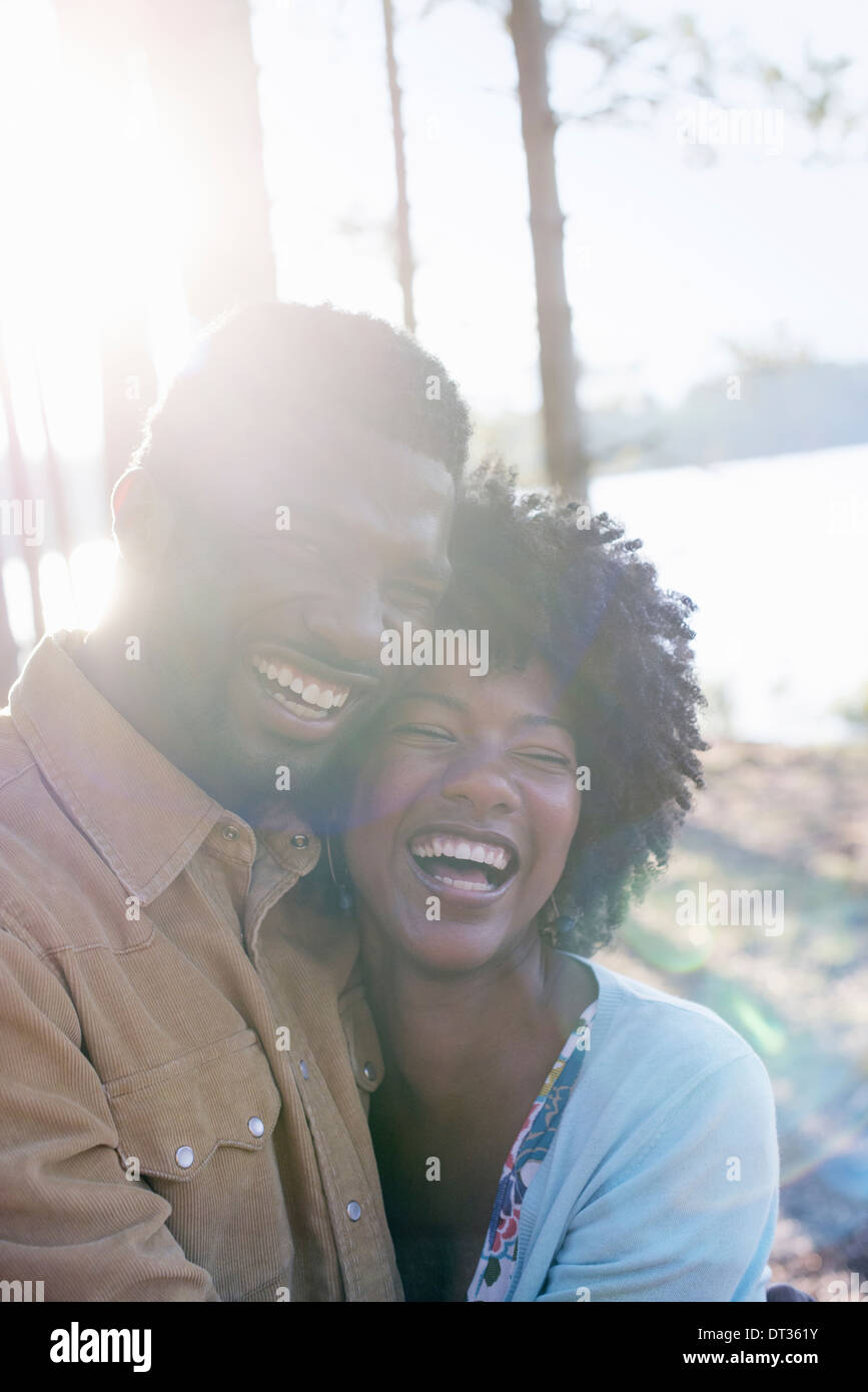 A happy couple in a shady spot in woodland in summer Hugging and ...