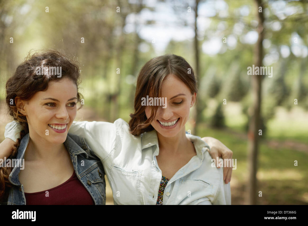 Two girls friends smiling with their arms around each other Stock Photo ...