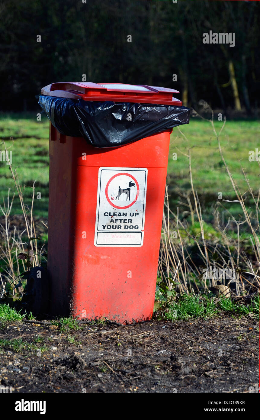 Red dog waste bin by a public footpath Stock Photo - Alamy