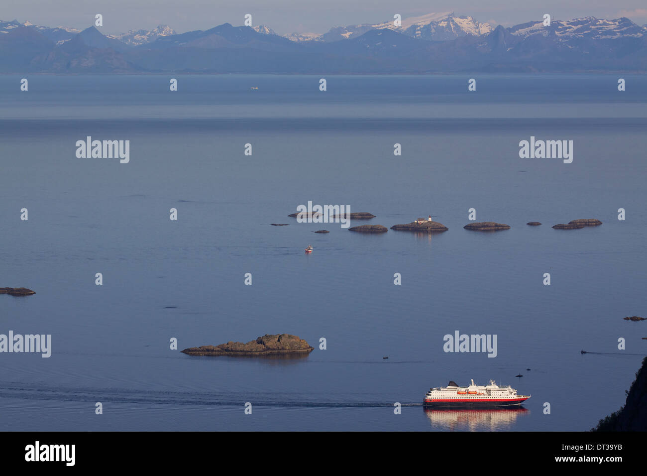 Large passenger ship passing by tiny rocky islets near Lofoten islands ...