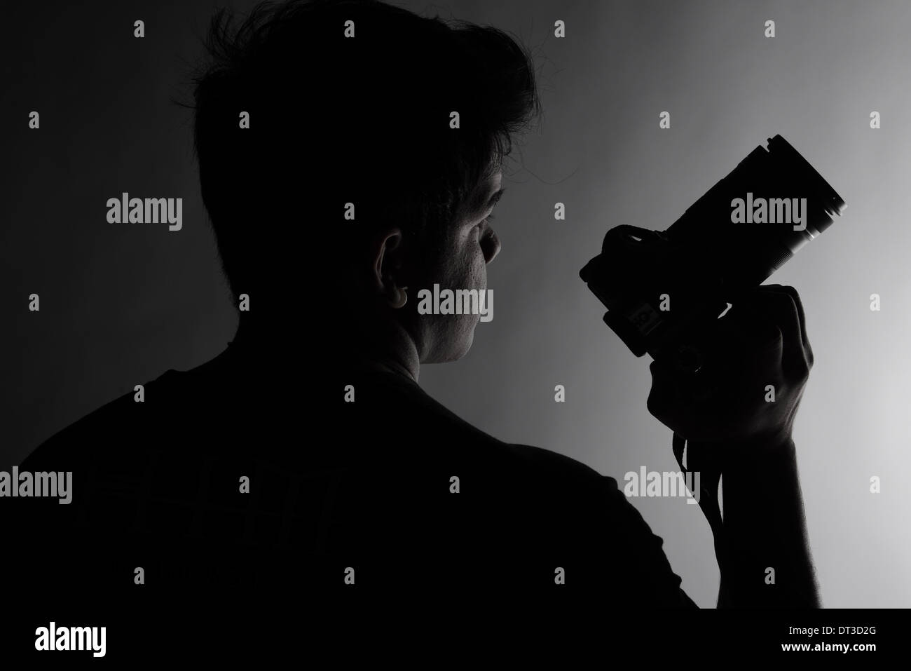 Boy holding up a camera, dramatic lighting in the studio Stock Photo ...