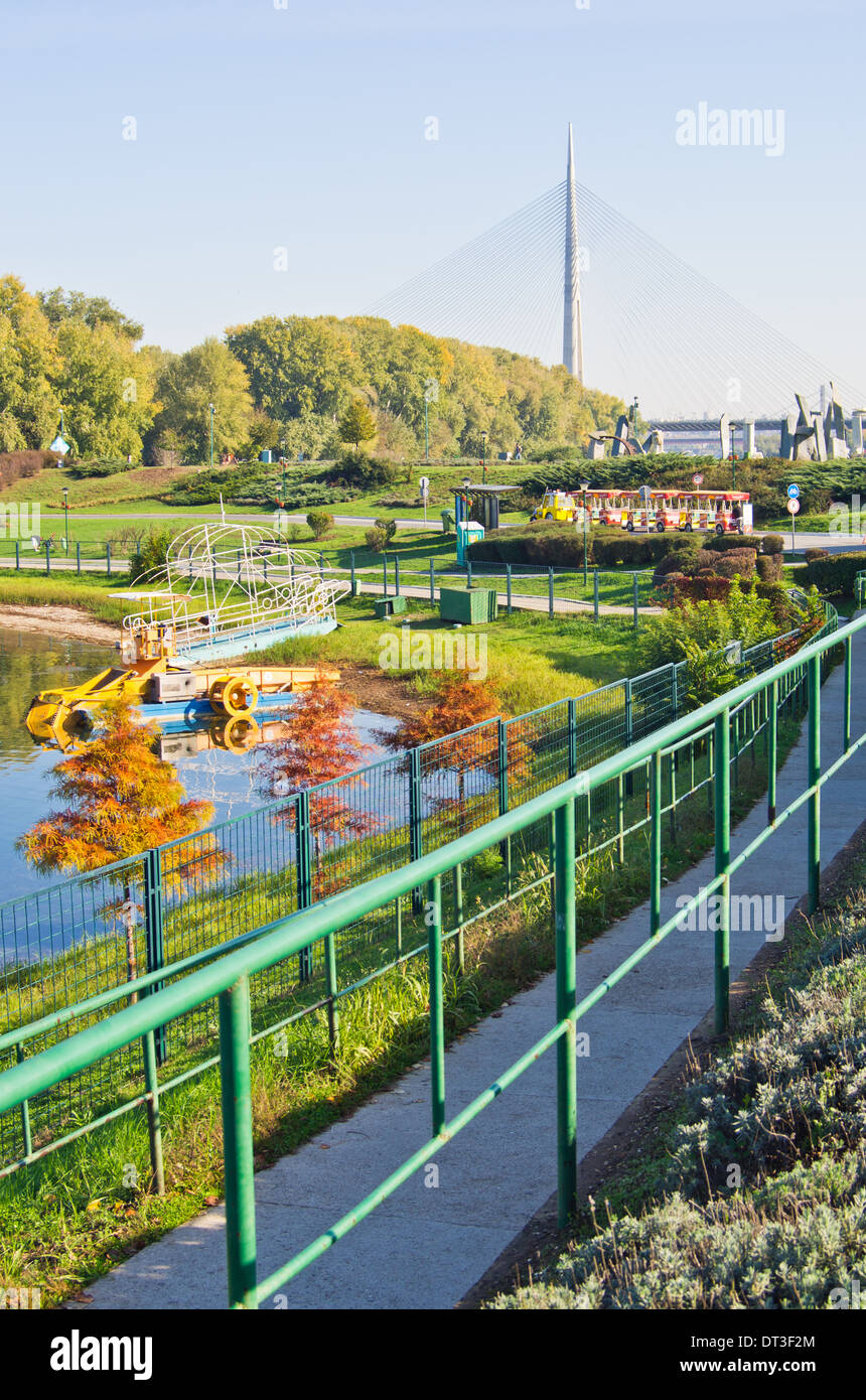 Ada lake at sunny morning, tourist trane and a cable bridge in a ...