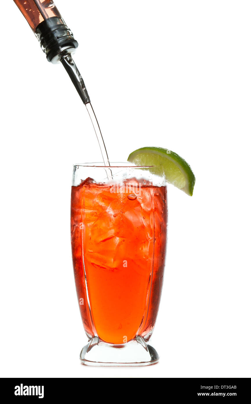 pouring a red cocktail in to a tall glass isolated on a white ...