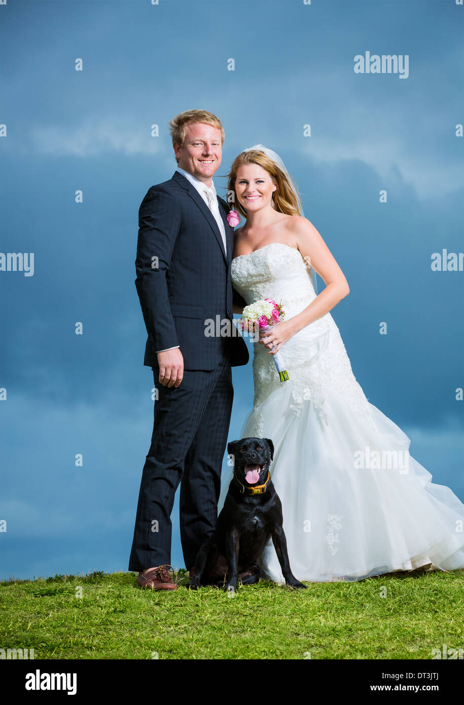 Wedding Couple, Happy bride and groom posing with their dog Stock Photo ...