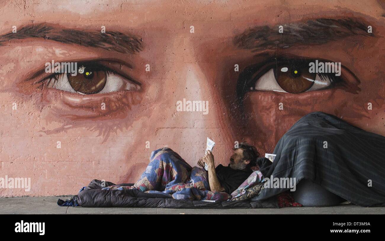 Los Angeles, California, USA. 7th Feb, 2014. A homeless man reads ...