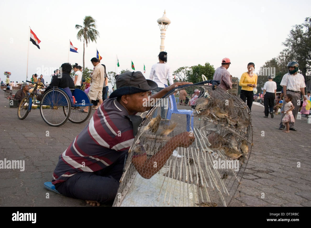 A bird salesman is preparing to sell birds to tourists on the Riverside ...