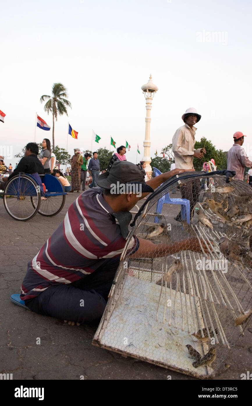 A bird salesman is preparing to sell birds to tourists on the Riverside ...