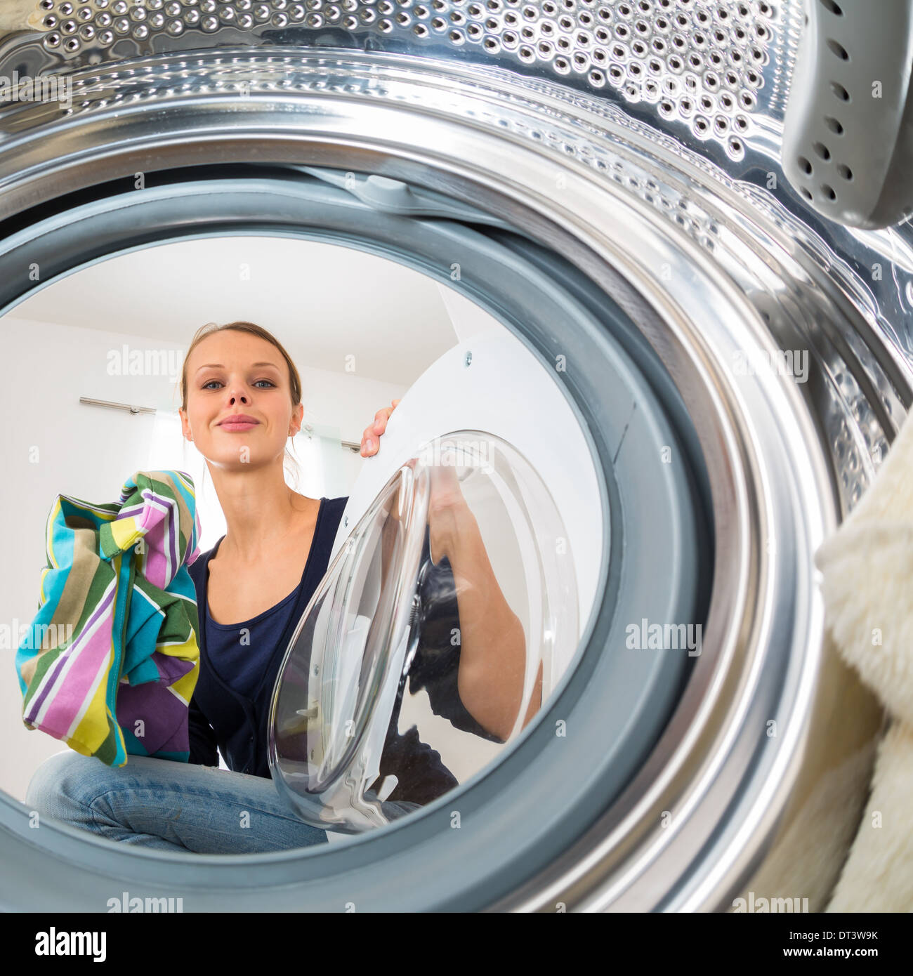 Housework: young woman doing laundry (shallow DOF; color toned image ...