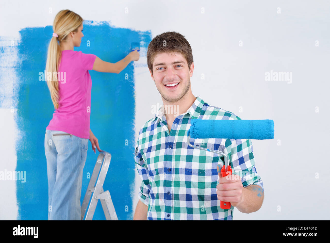 happy couple paint wall at new home Stock Photo - Alamy