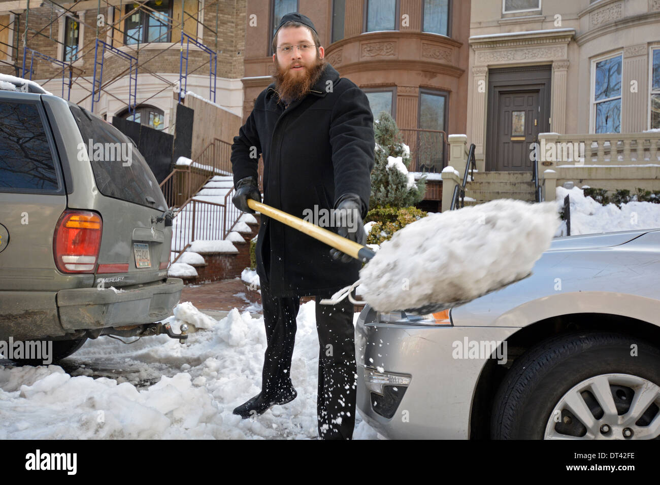 Hasidic religious Jewish rabbi shoveling snow in Crown Heights ...