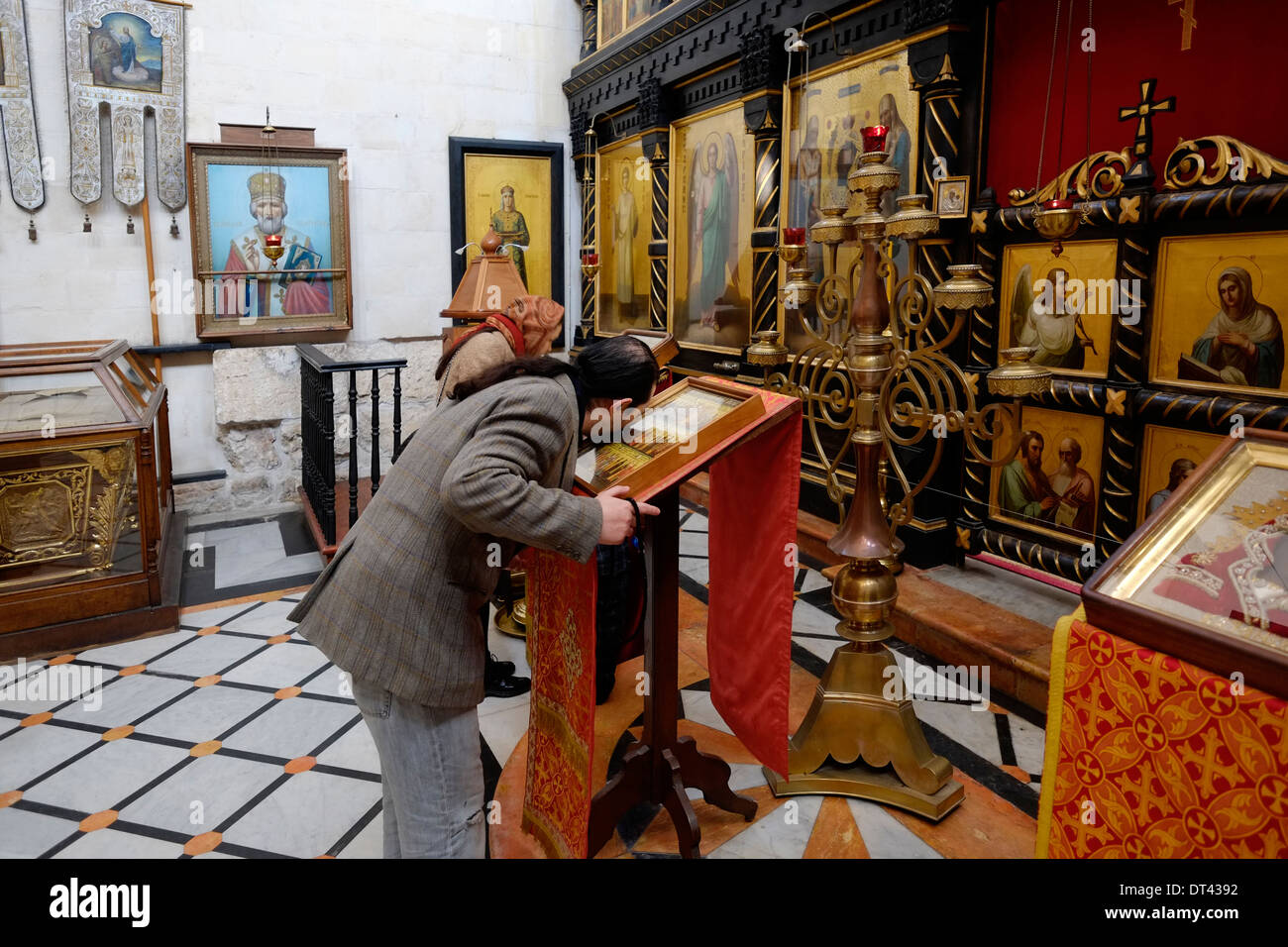 A Russian Orthodox pilgrim kissing a religious icon at the Church of ...