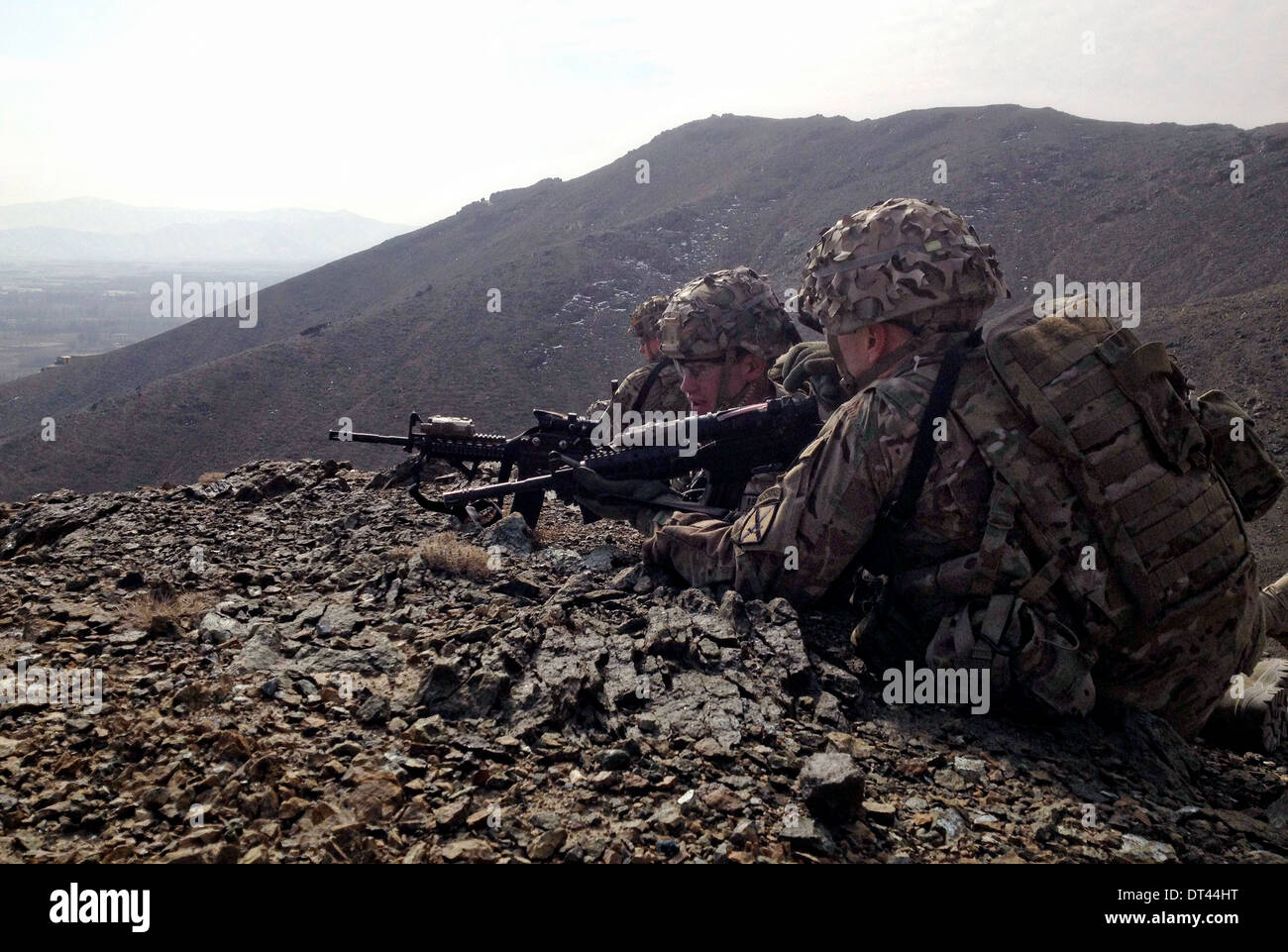 US soldiers from the 10th Mountain Division on patrol in rugged terrain ...