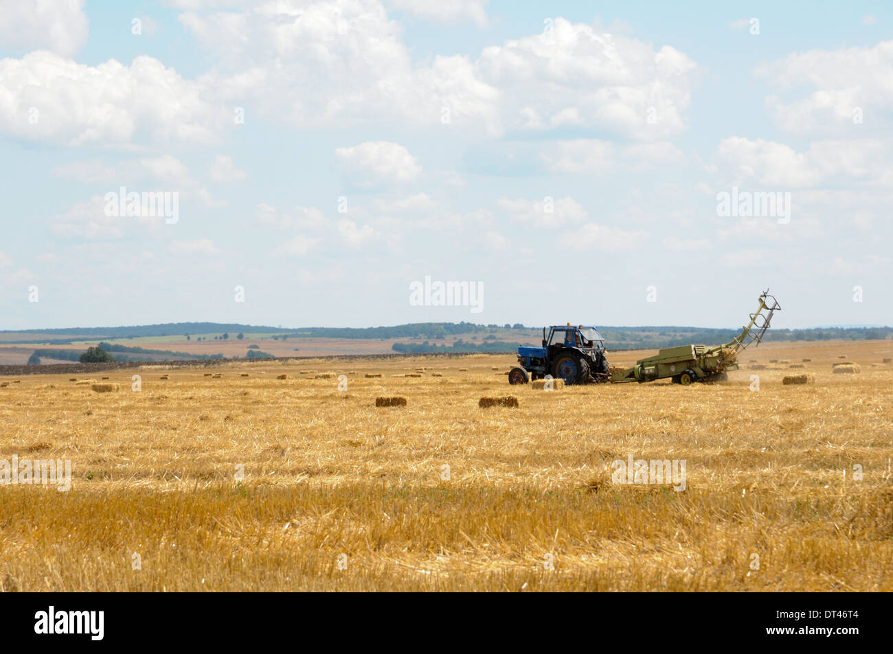 Tractor baled straw after harvest Stock Photo - Alamy