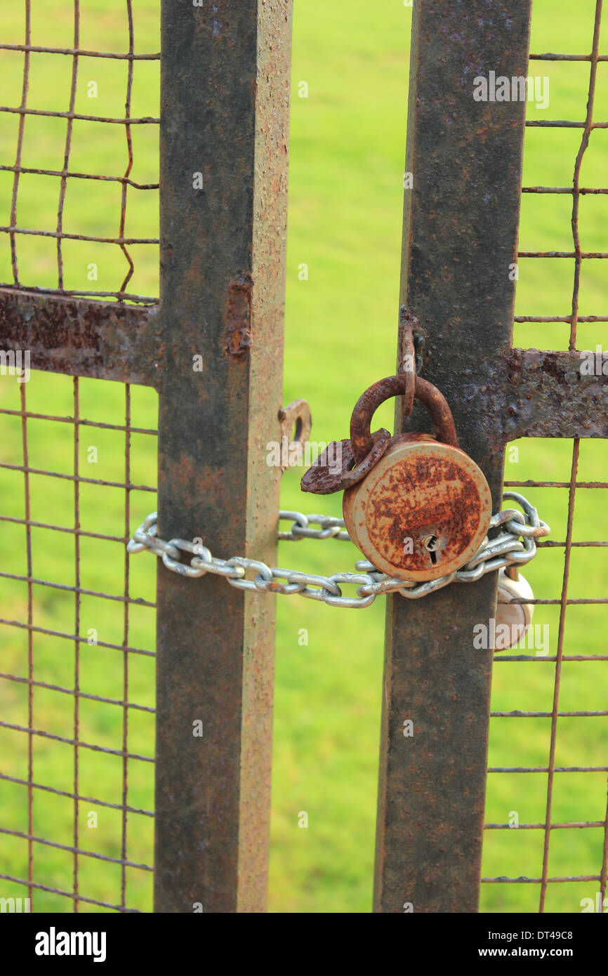 Locked gate with a rusted lock Stock Photo - Alamy