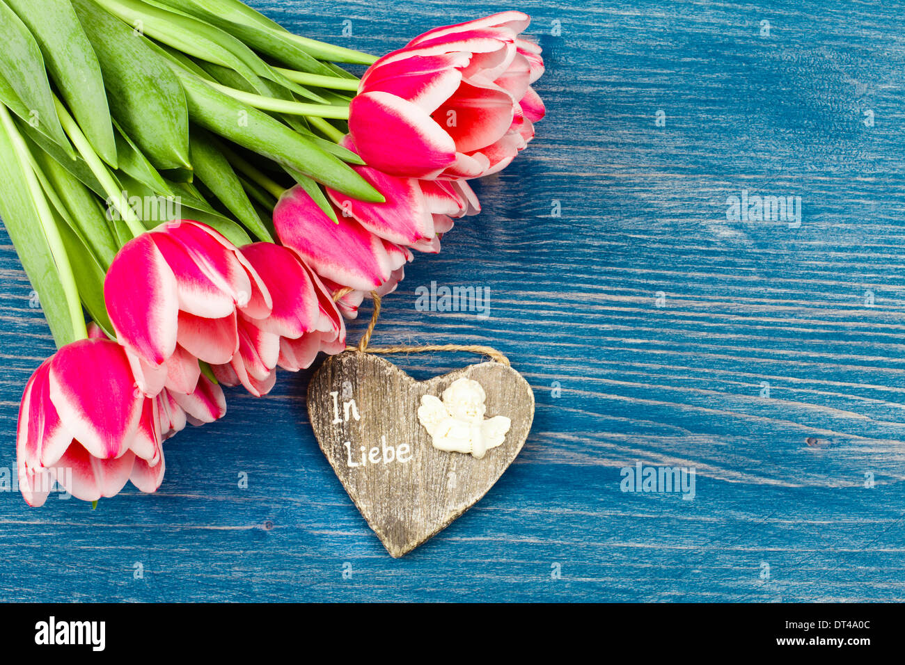Tulip bouquet on blue background and wooden heart Stock Photo - Alamy