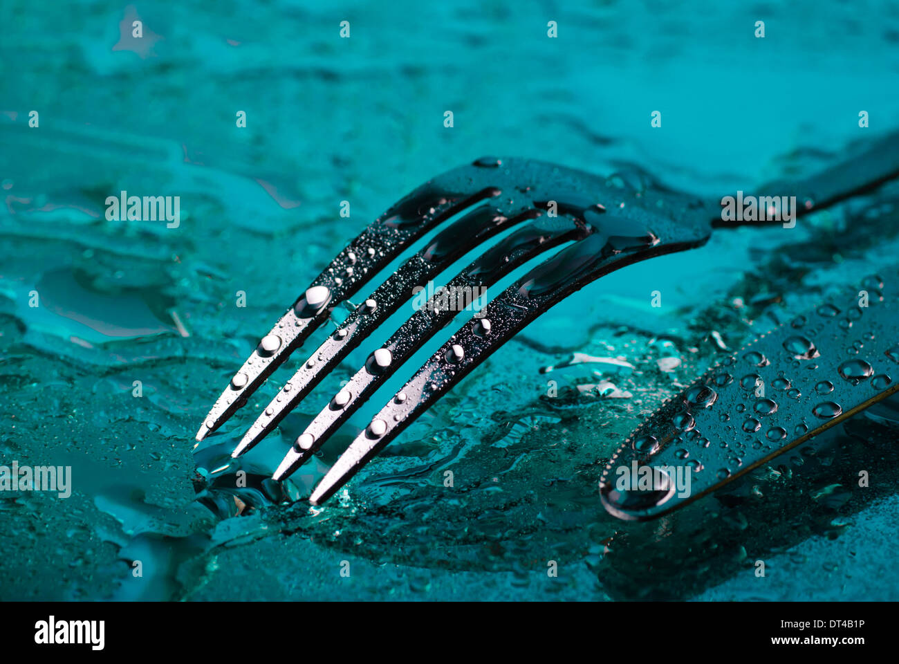 Fork and knife under the blue water Stock Photo - Alamy