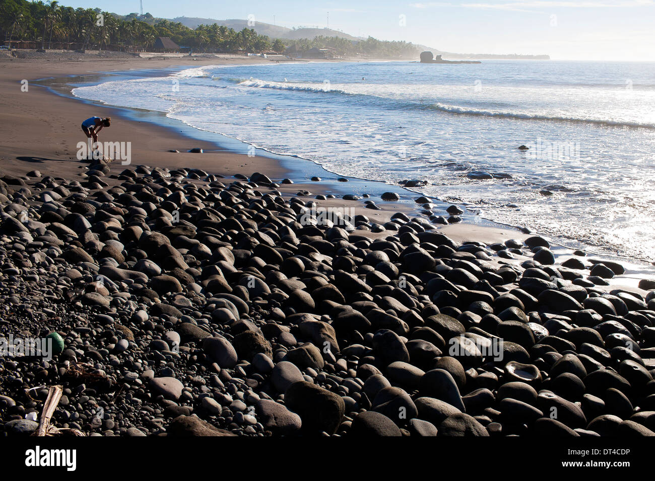 Large rocks on the north end of El Tunco beach as a runner rests in El ...