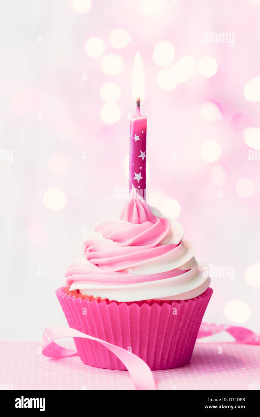 Pink birthday cupcake with a single candle Stock Photo - Alamy