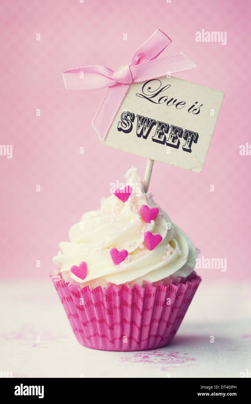 Cupcake with "love is sweet" pick Stock Photo - Alamy