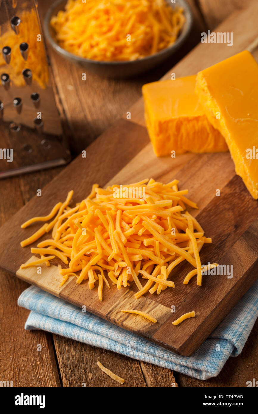 Organic Shredded Sharp Cheddar Cheese on a Cutting Board Stock Photo ...