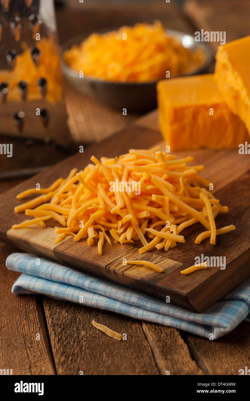 Organic Shredded Sharp Cheddar Cheese on a Cutting Board Stock Photo ...