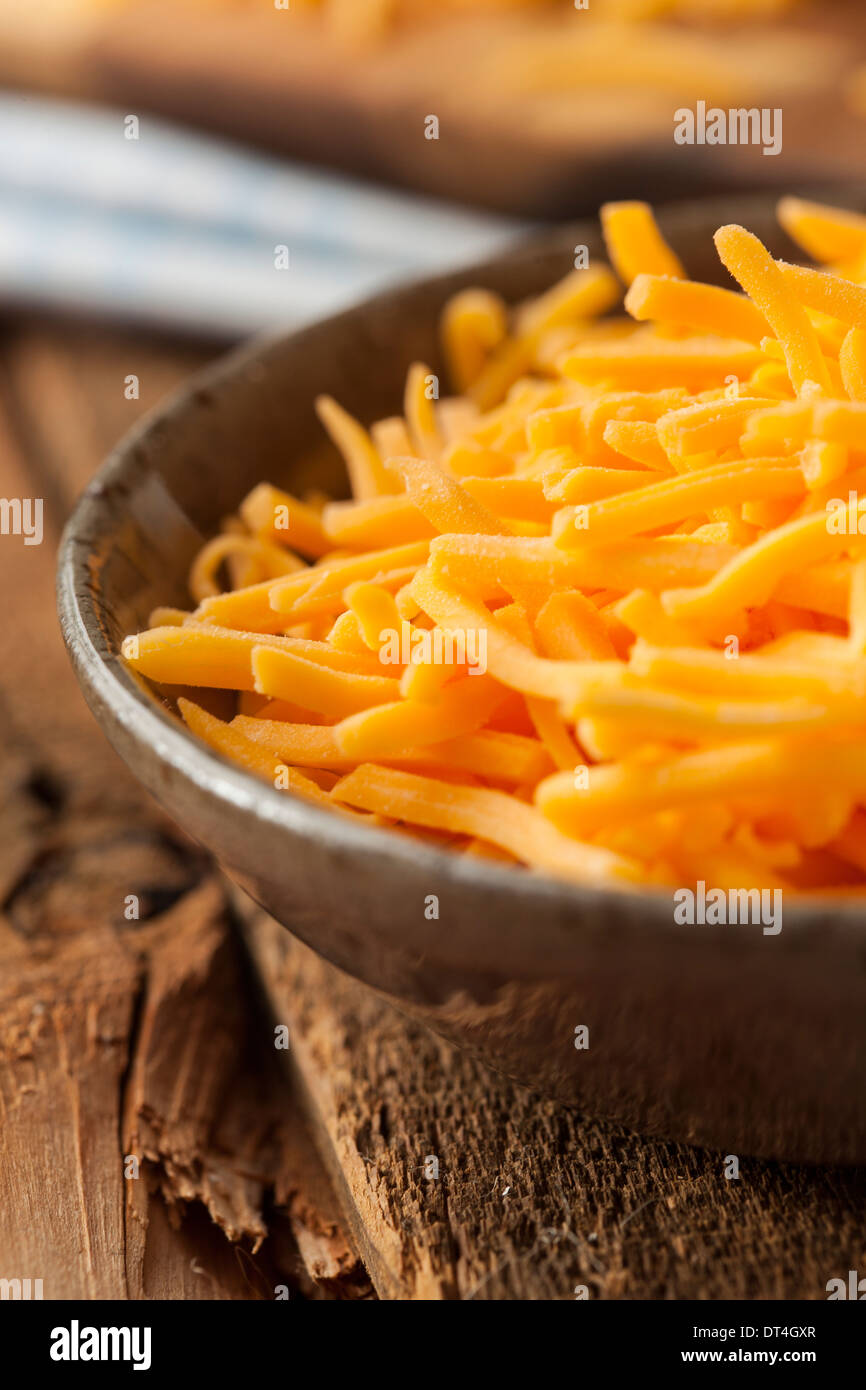 Organic Shredded Sharp Cheddar Cheese on a Cutting Board Stock Photo ...