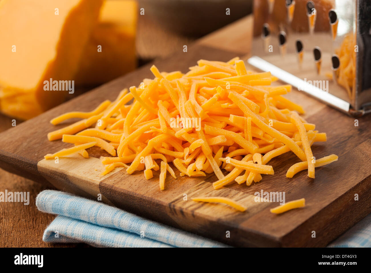 Organic Shredded Sharp Cheddar Cheese on a Cutting Board Stock Photo ...