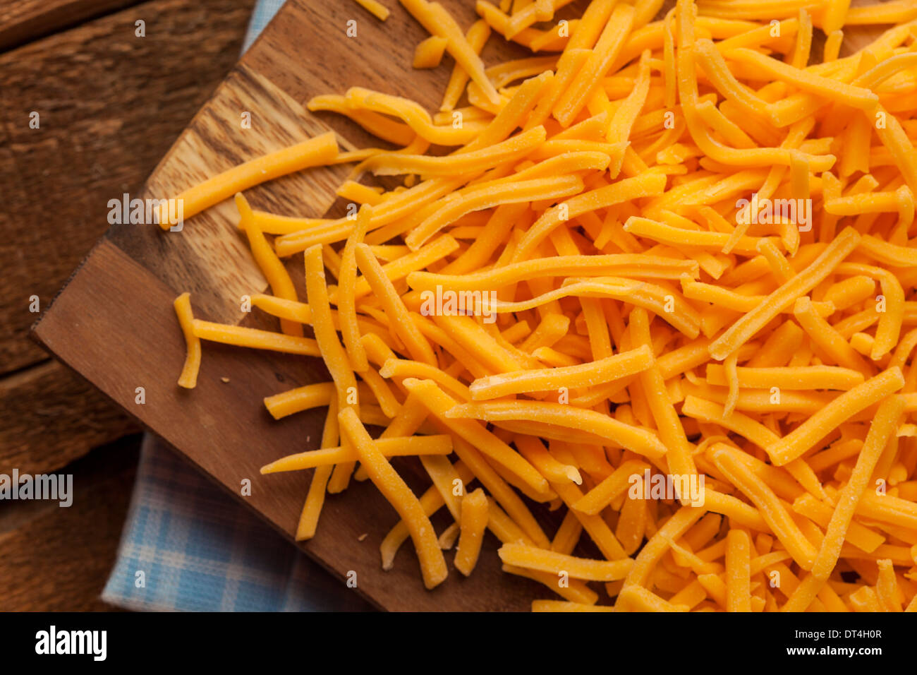 Organic Shredded Sharp Cheddar Cheese on a Cutting Board Stock Photo ...
