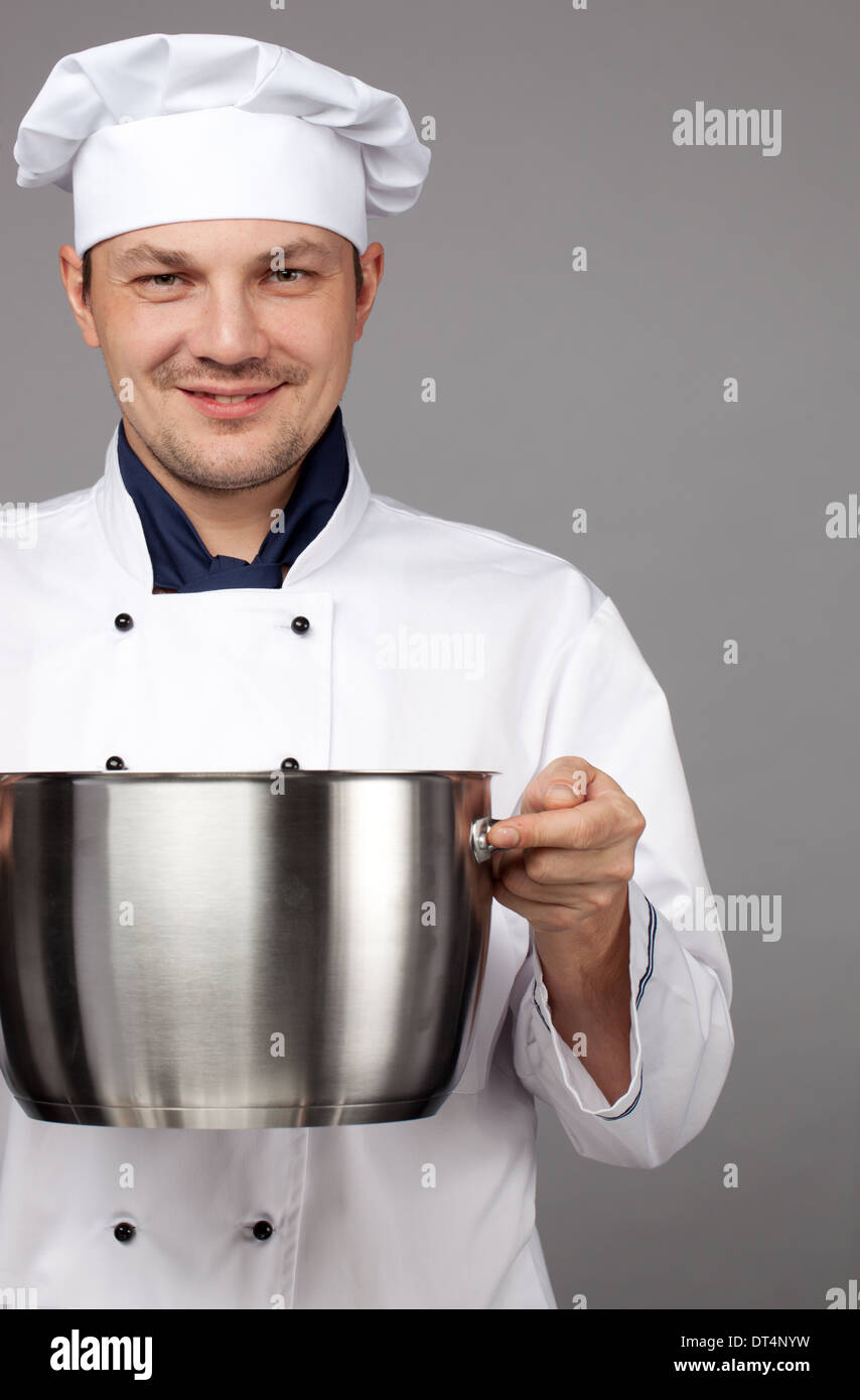 Chef cooking with pot in uniform on grey background Stock Photo - Alamy