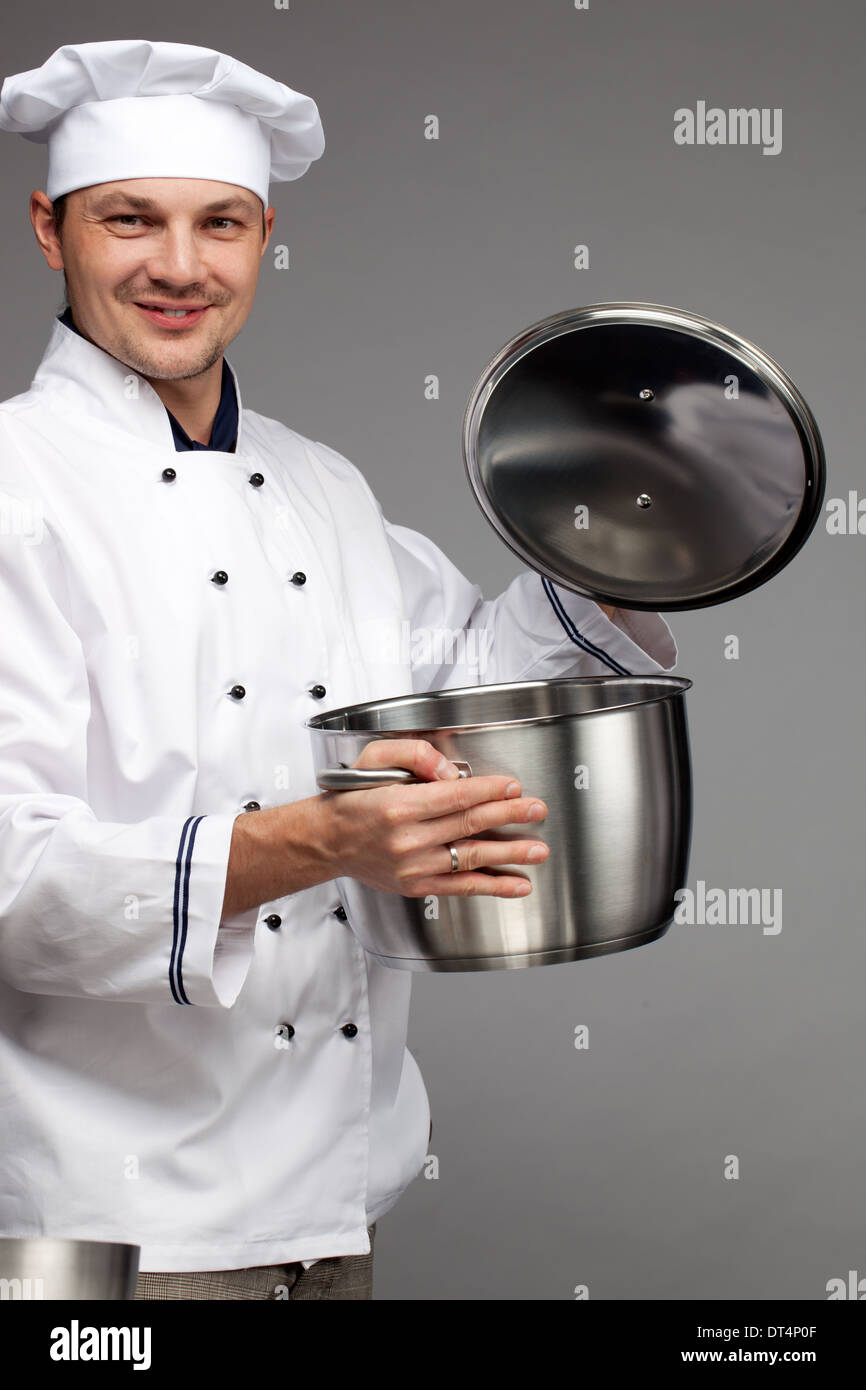 Chef cooking with pot in uniform on grey background Stock Photo - Alamy