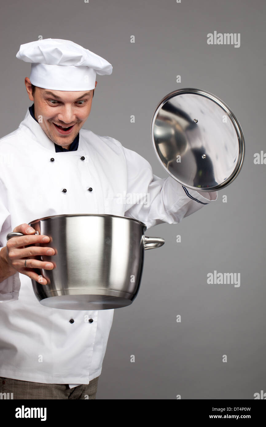 Chef cooking with pot in uniform on grey background Stock Photo - Alamy