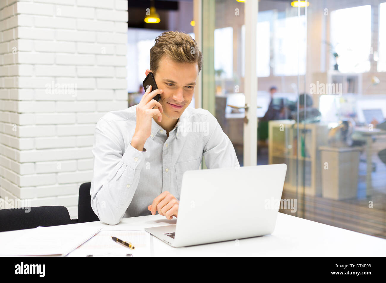 Businessman calling with mobile phone in office Stock Photo - Alamy