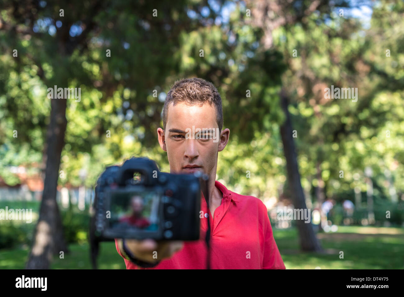 Young man with photo camera in the park Stock Photo - Alamy