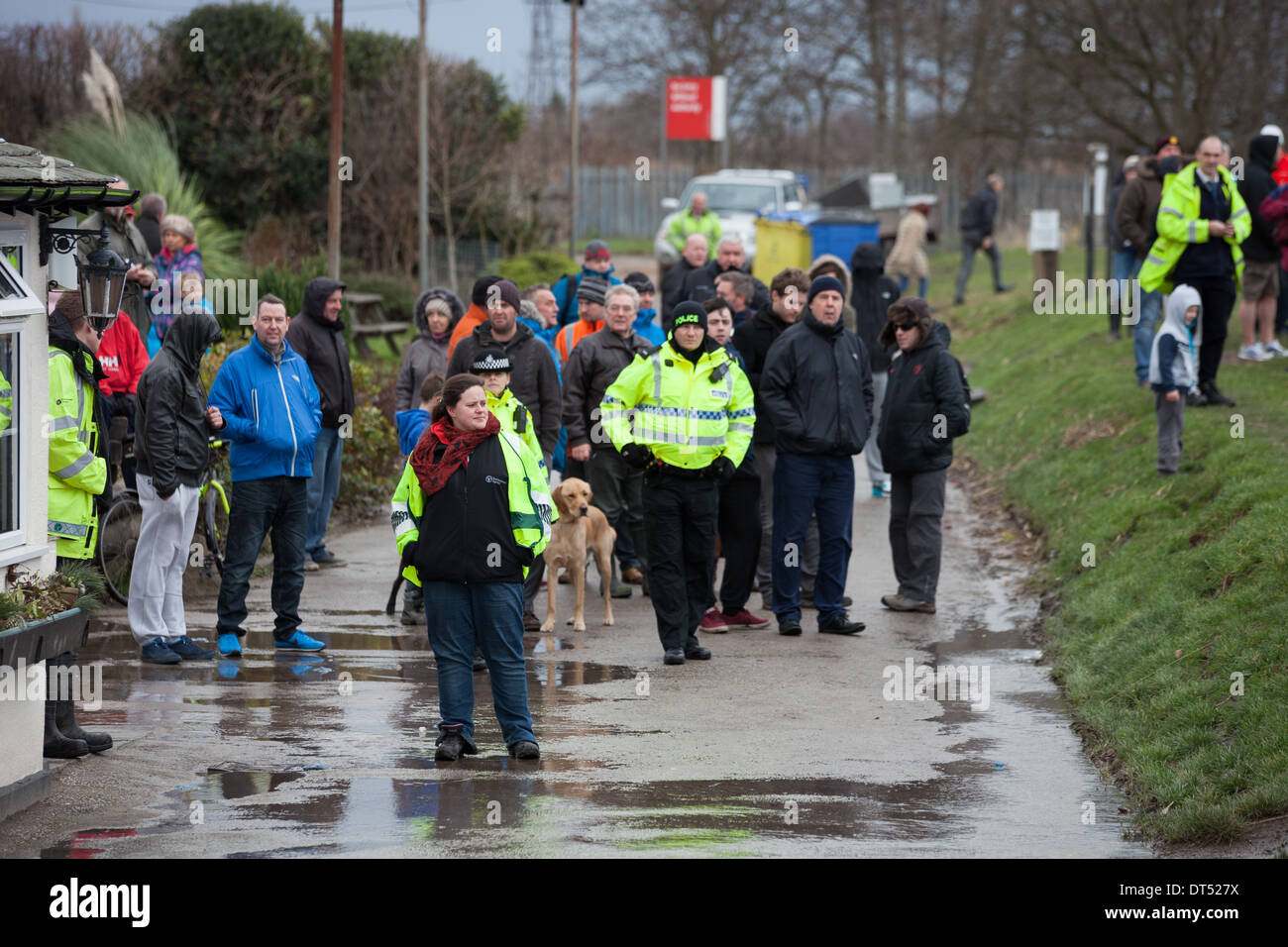Environment Agency staff look on as Police keep onlookers back from ...
