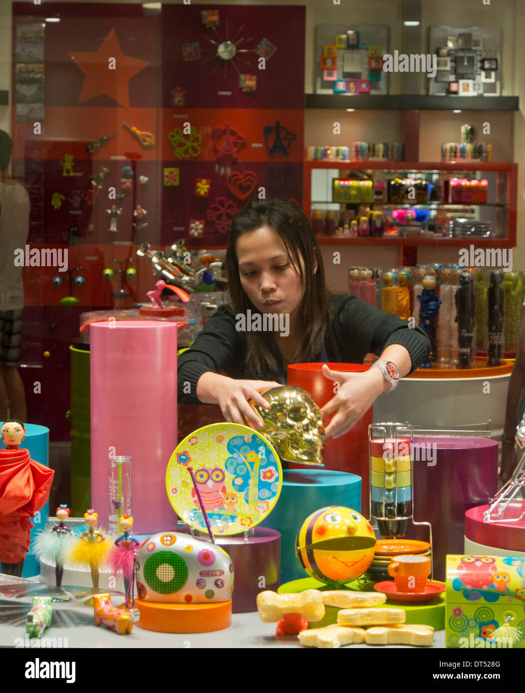 Shop assistant arranging window display along Orchard Road luxury ...