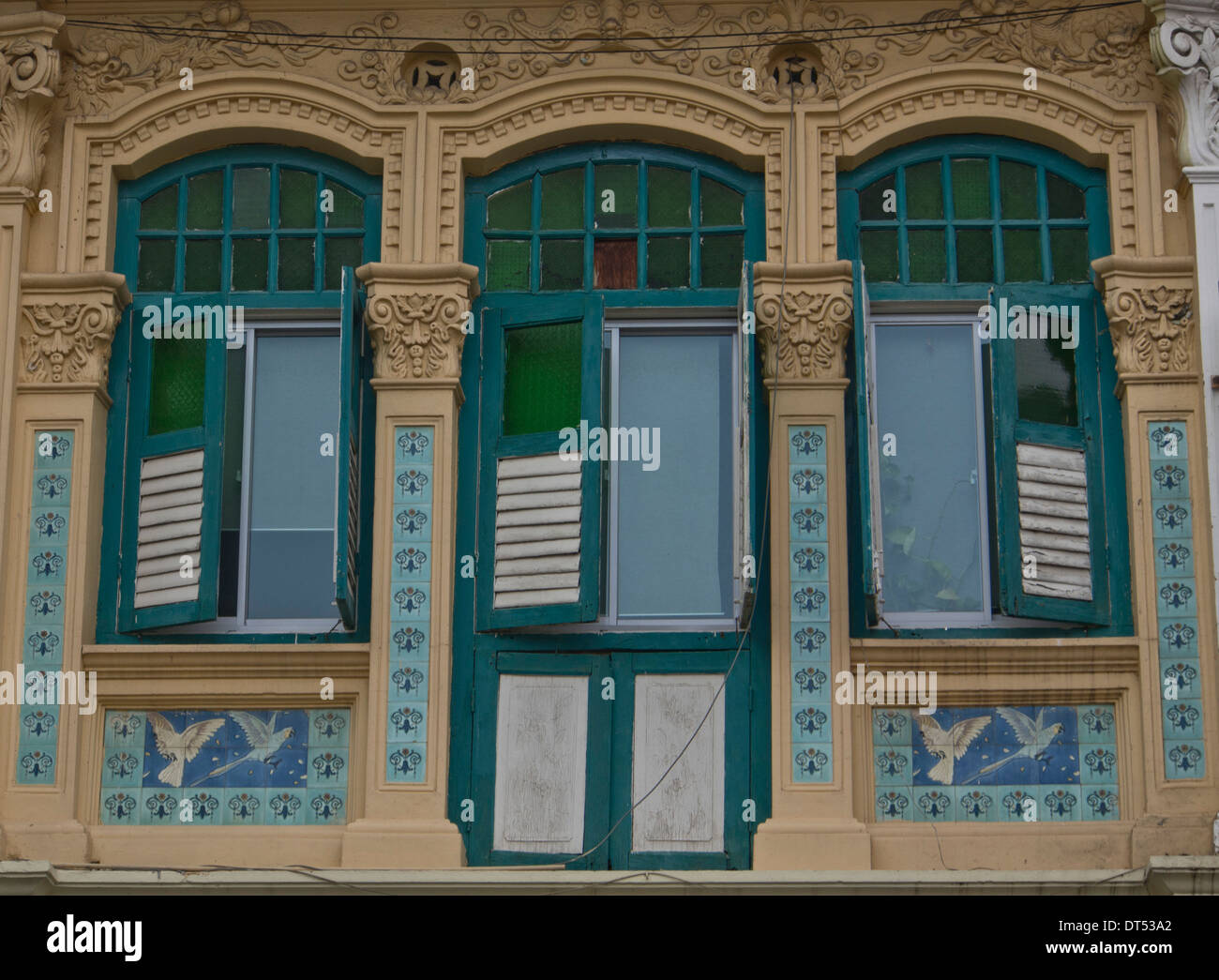 Traditional 1920s shophouse façade with shutters and tiles in Singapore ...