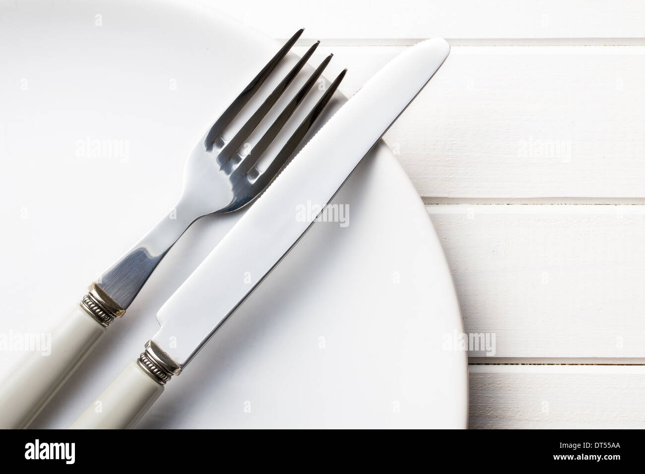 plate with cutlery on kitchen table Stock Photo - Alamy