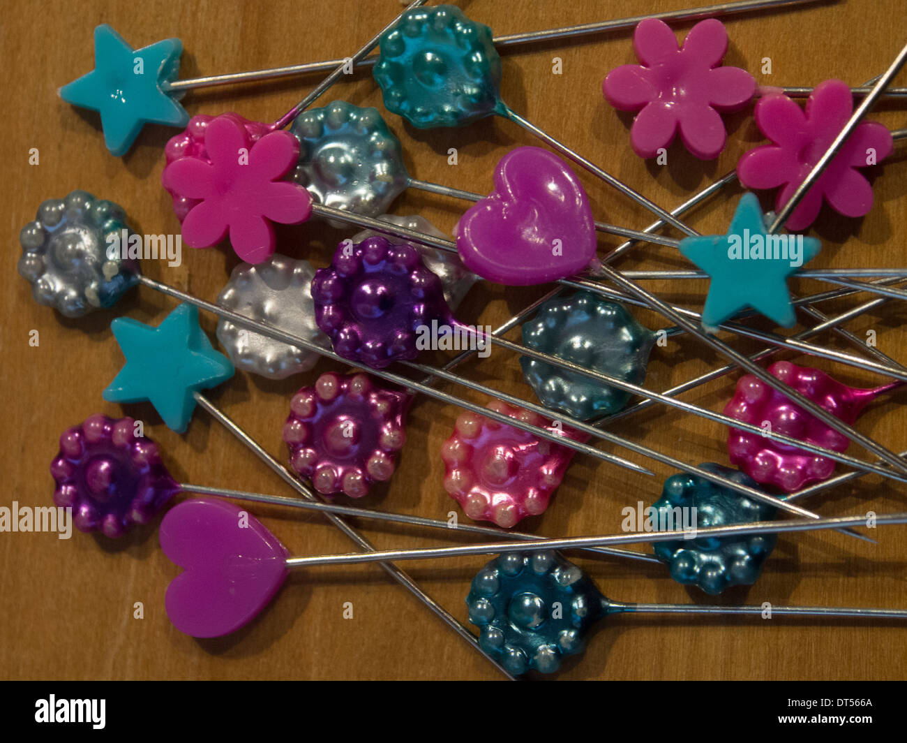 A close-up of some colourful long pins with decorative plastic heads ...