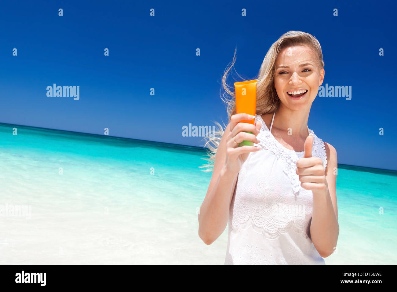 Portrait of woman holding sunscreen cream on beach, beauty concept ...