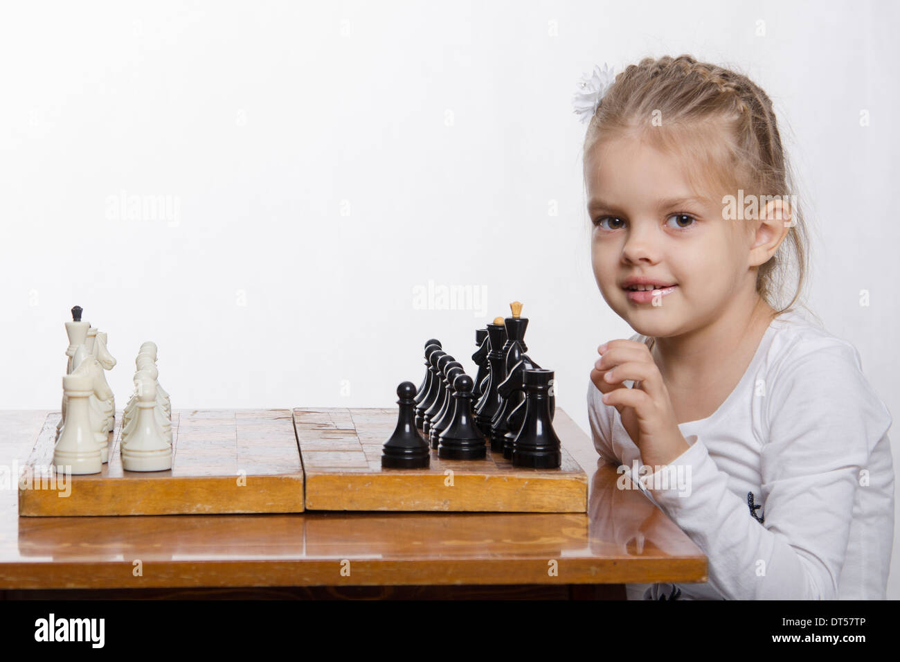 The girl sitting at the table, on which stands the chess Board. The ...