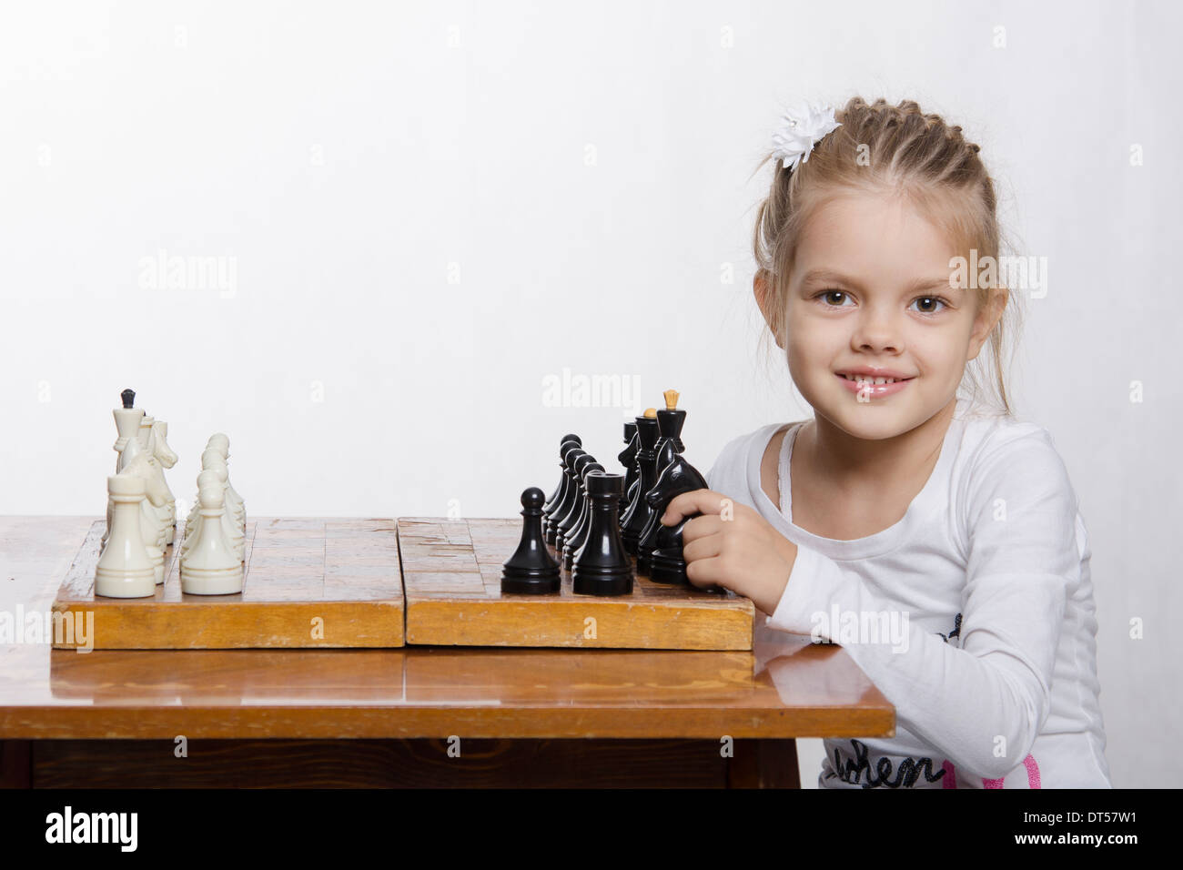 The girl sitting at the table, on which stands the chess Board. The ...