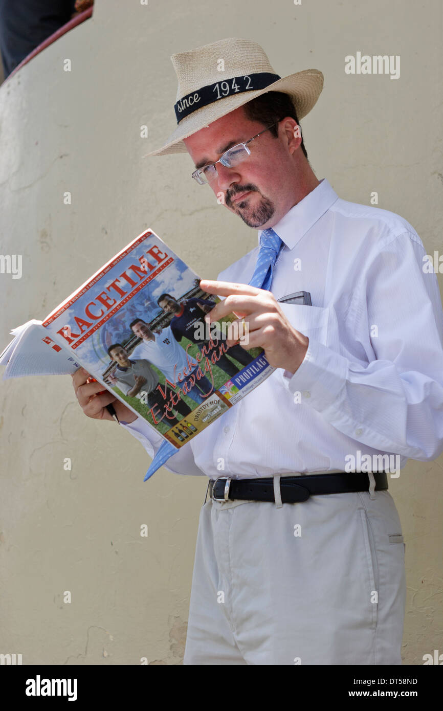 A spectator checking out the horse racing timetable before the next ...