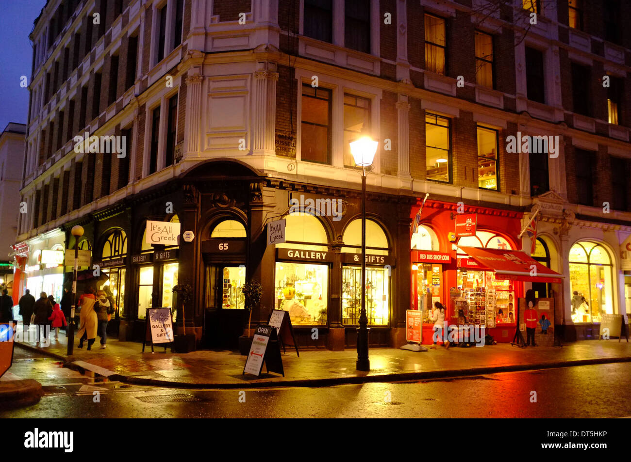 people walking by gift shops on a corner near British Museum at night ...