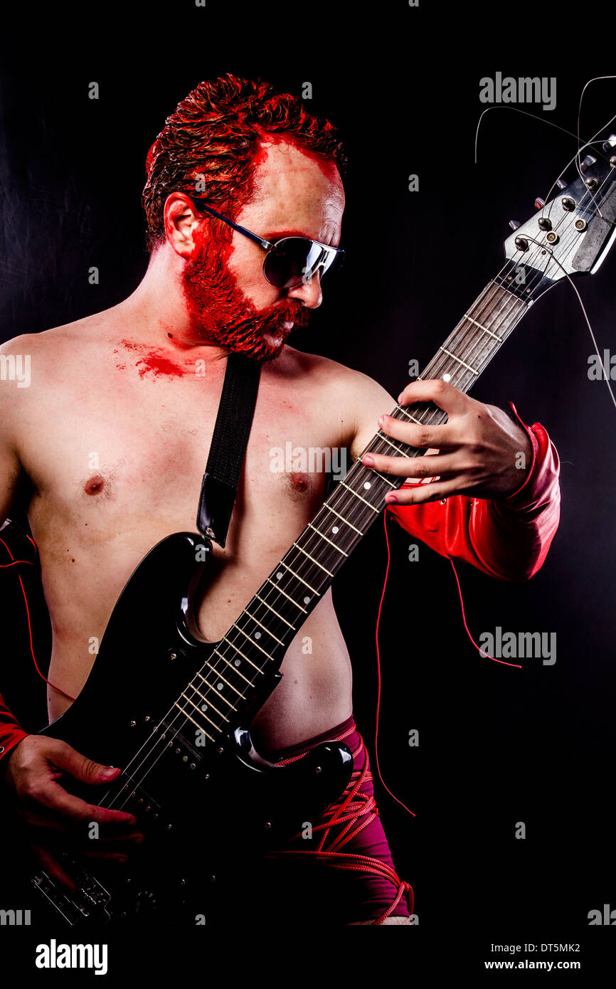 guitarist with electric guitar black, wearing face paint and red ...
