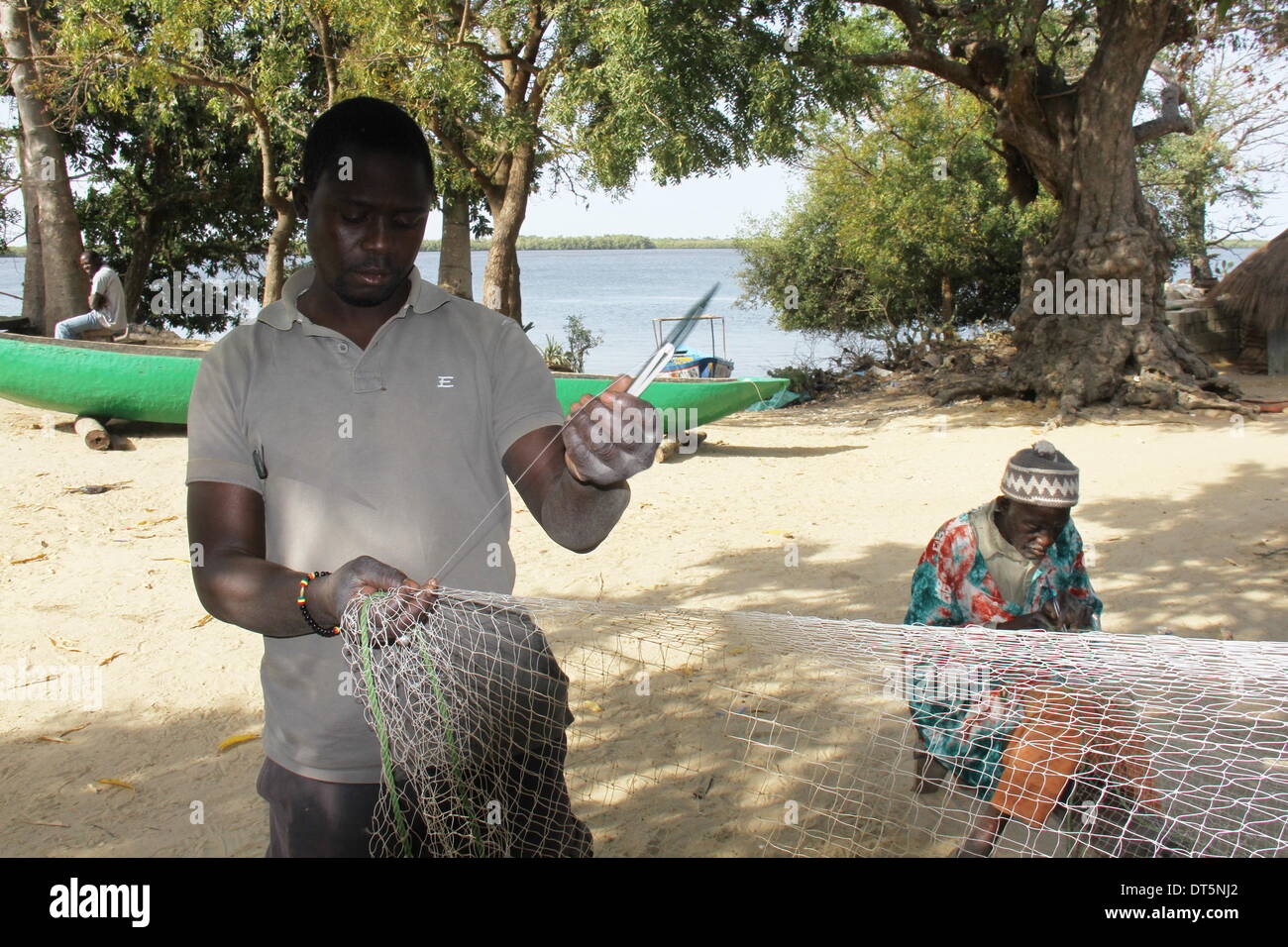 Dakar, Senegal. 4th Feb, 2014. Villagers weave a fishing net in a ...
