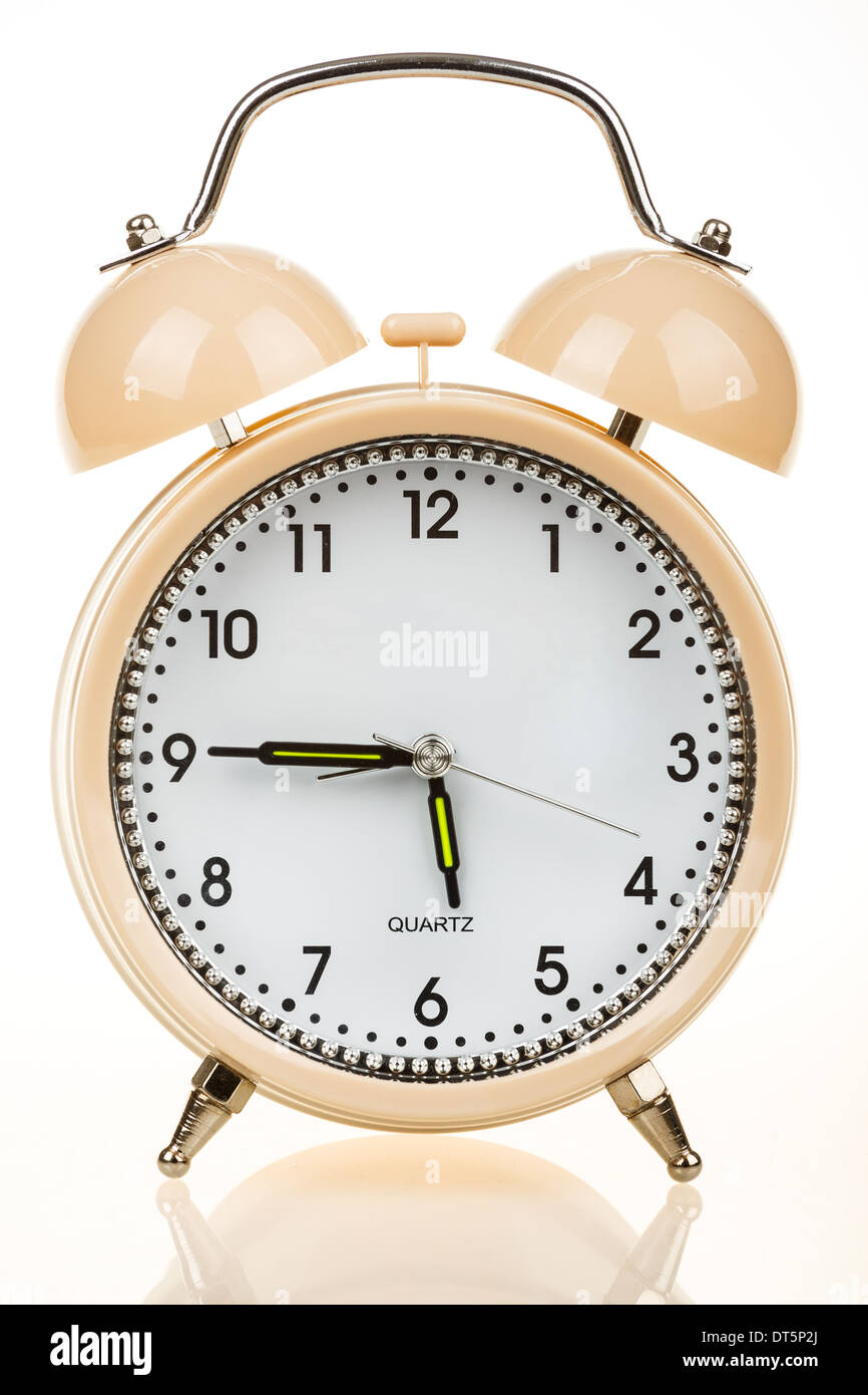 classic alarm clock on white table with reflection Stock Photo - Alamy