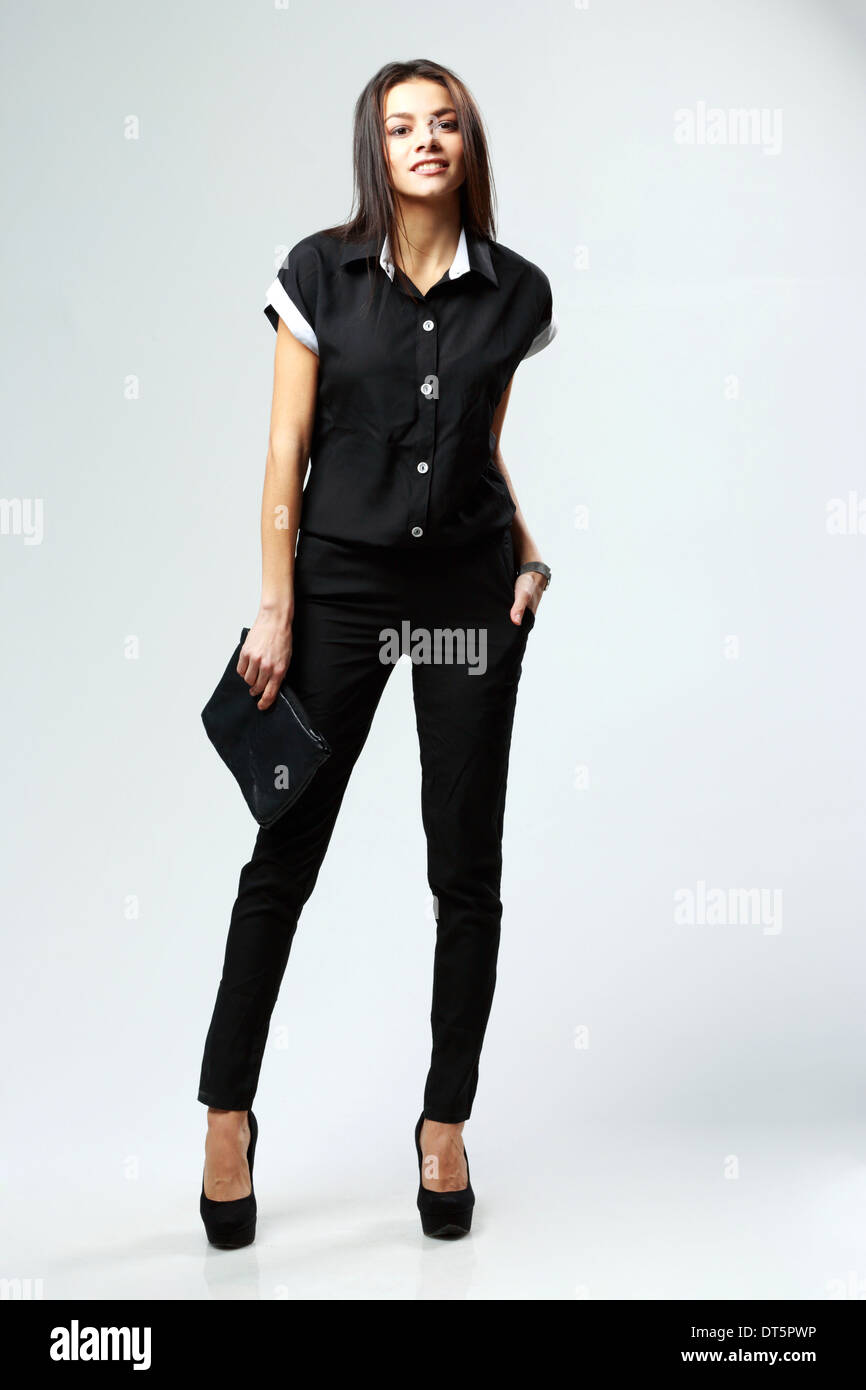 Full-length portrait of a young happy woman in style clothes standing ...